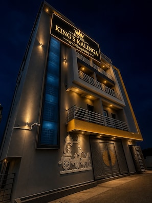 Um hotel de vários andares com uma placa de destaque que diz 'King's Kalinga Hotel by CN Hospitality'.