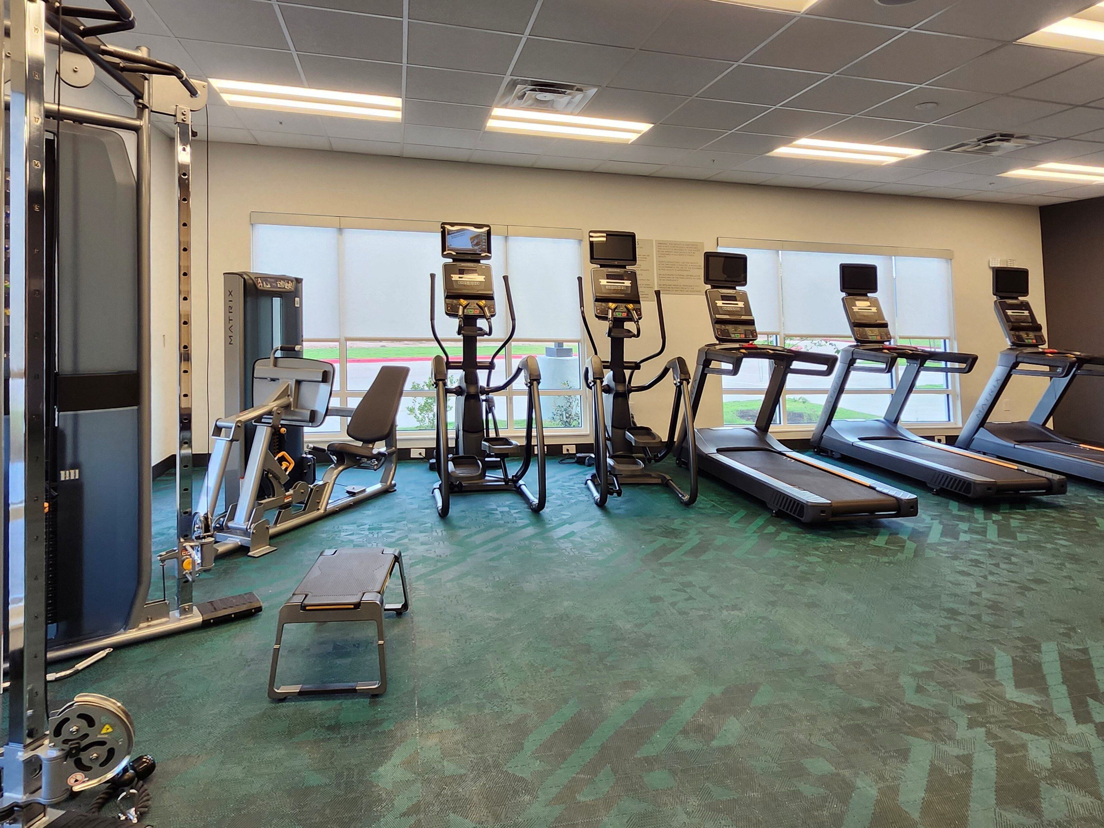 Academia com esteiras, elípticos e equipamentos de musculação.