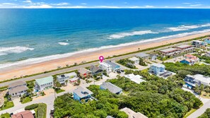 Uma área residencial à beira-mar, com casas, praia e estrada.