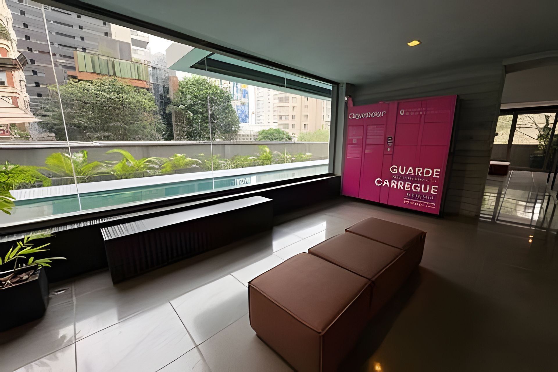 Um interior moderno com um banco, uma janela de vidro e uma parede rosa com texto.