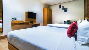 Quarto de hotel com uma cama, televisão, escrivaninha e guarda-roupa.