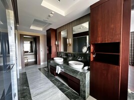 Um banheiro moderno com duas pias, um espelho grande e um lavatório com toalha.