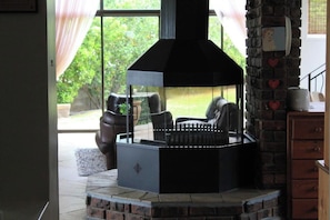 Uma lareira com chaminé, moldura de tijolos e vista para o exterior.