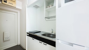 Uma cozinha moderna com máquina de lavar louça embutida, pia e micro-ondas.