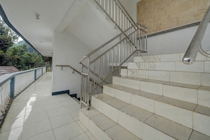 Uma escadaria com grades de metal e azulejos bege.