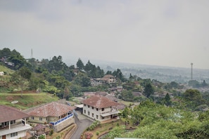 Uma área residencial com casas, céu claro e uma vista distante de um horizonte urbano.
