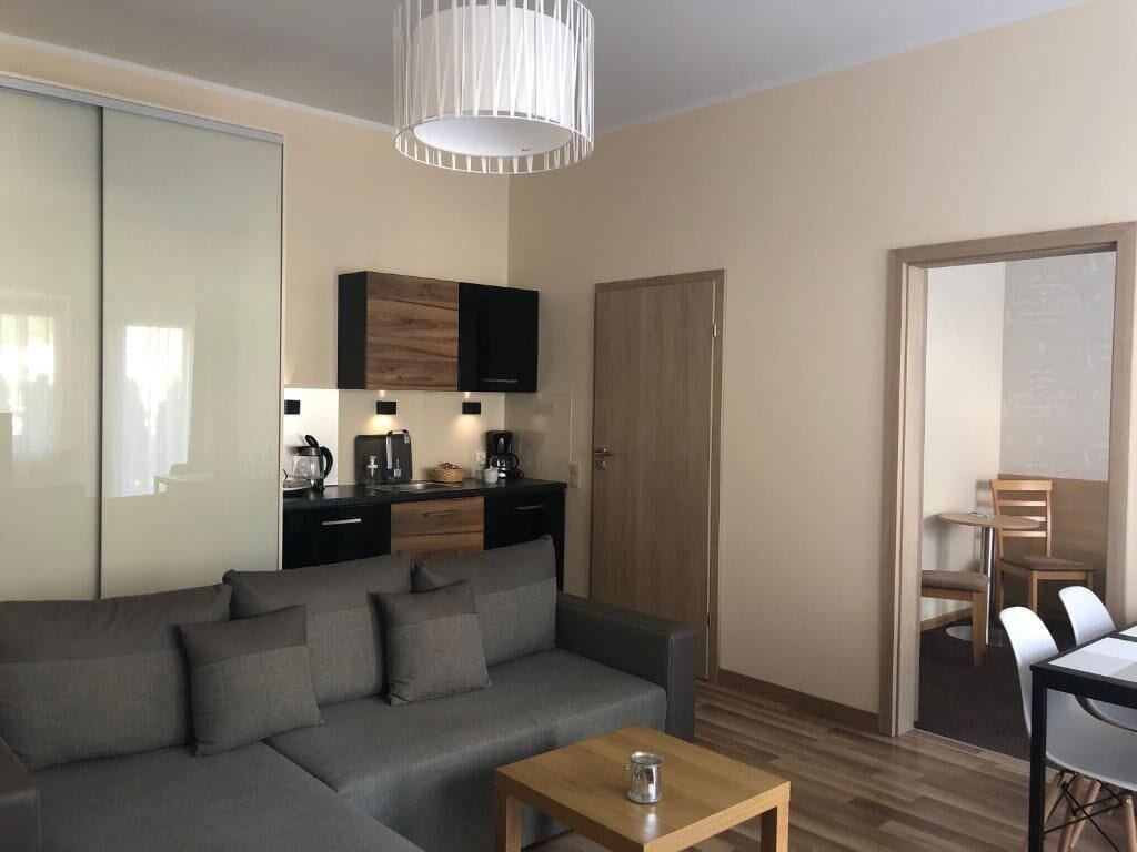 Uma sala de estar moderna com um sofá, uma mesa de centro e uma área de jantar com cadeiras.