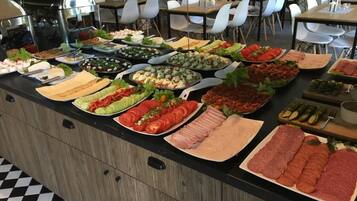 Buffet com diversas opções de comida, incluindo saladas, carnes e legumes.