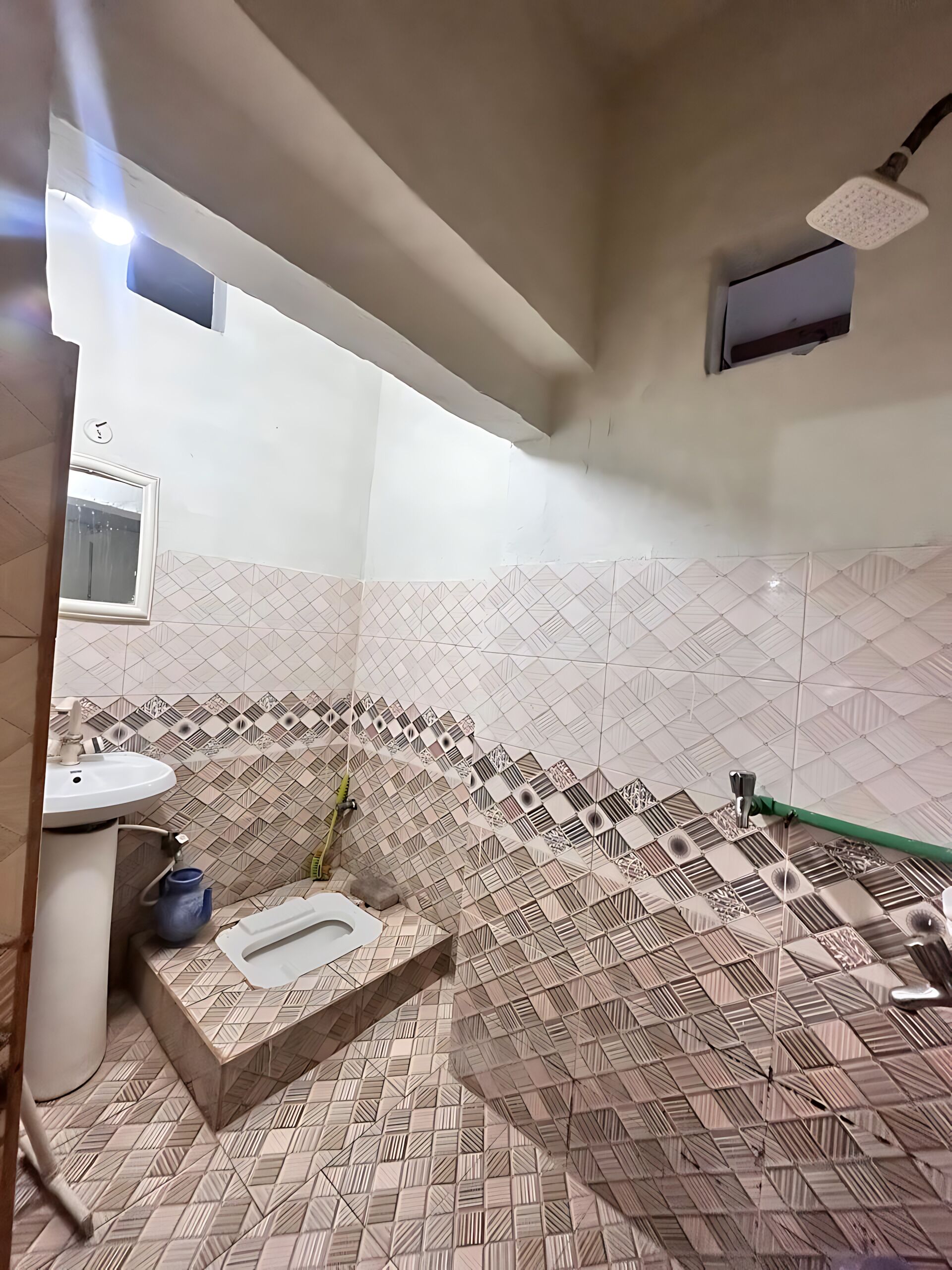Uma casa de banho com sanita, lavatório e zona de duche.