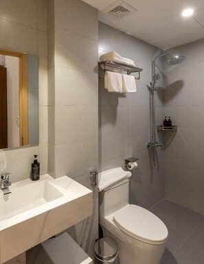 Uma casa de banho moderna com sanita, lavatório e chuveiro.