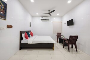 Quarto de hotel moderno com uma cama, uma escrivaninha e uma cadeira.