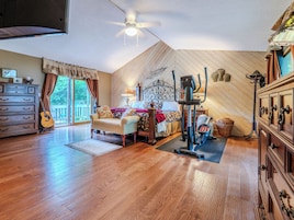 Quarto com cama, guitarra, ventilador de teto e equipamento de ginástica.