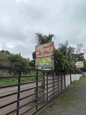 Placa indicativa para um jardim com números de contato e indicações.