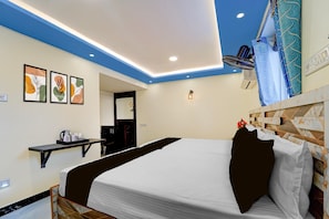 Quarto de hotel com cama, mesa de cabeceira e ar condicionado fixado na parede.