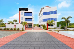 Um edifício moderno com uma placa indicando que é administrado pela OYO.