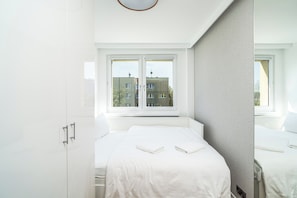 Quarto com cama, janela e guarda-roupa.