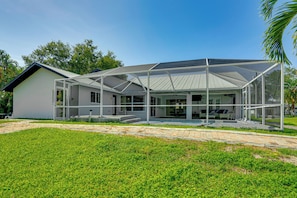 Uma casa moderna com área externa coberta, piscina e gramado bem cuidado.