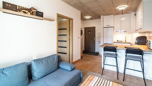 Um espaço compacto com cozinha compacta, sofá e área de bar.