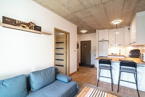 Um espaço compacto com cozinha compacta, sofá e área de bar.