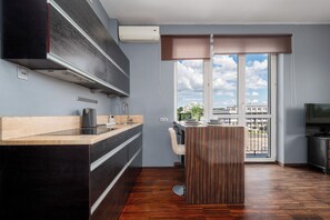 Uma cozinha moderna com fogão embutido, cafeteira e janela com vista para a cidade.