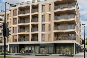 Um edifício residencial com várias andares, varandas, janelas amplas e um design arquitetônico moderno.