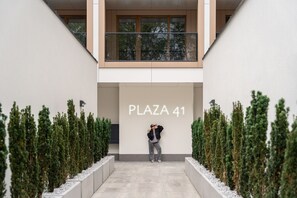 Uma pessoa em frente a um prédio com uma placa que diz 'PLAZA 41'.