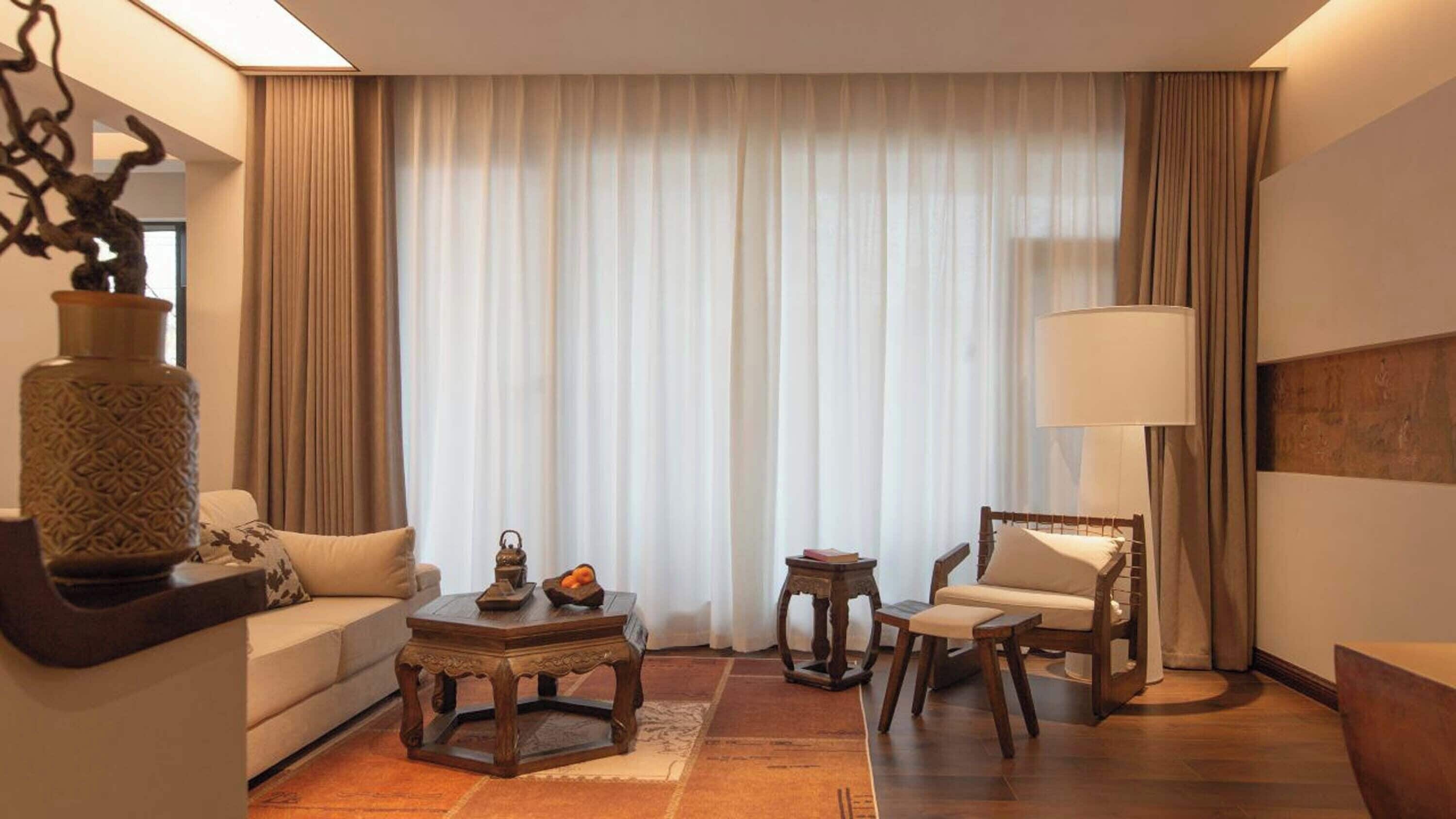Uma sala de estar moderna com sofá, poltrona, mesa de centro e luminária.