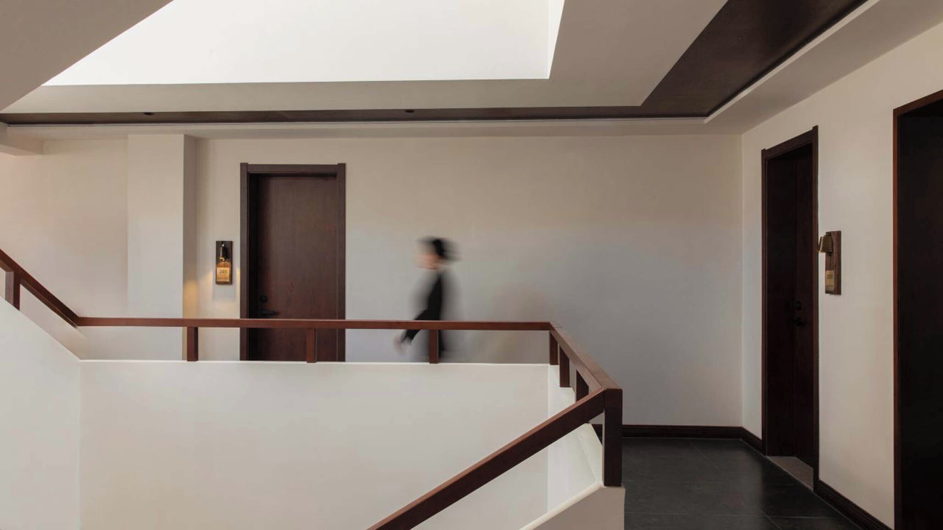 Interior moderno com escada, porta e luminária fixada na parede.