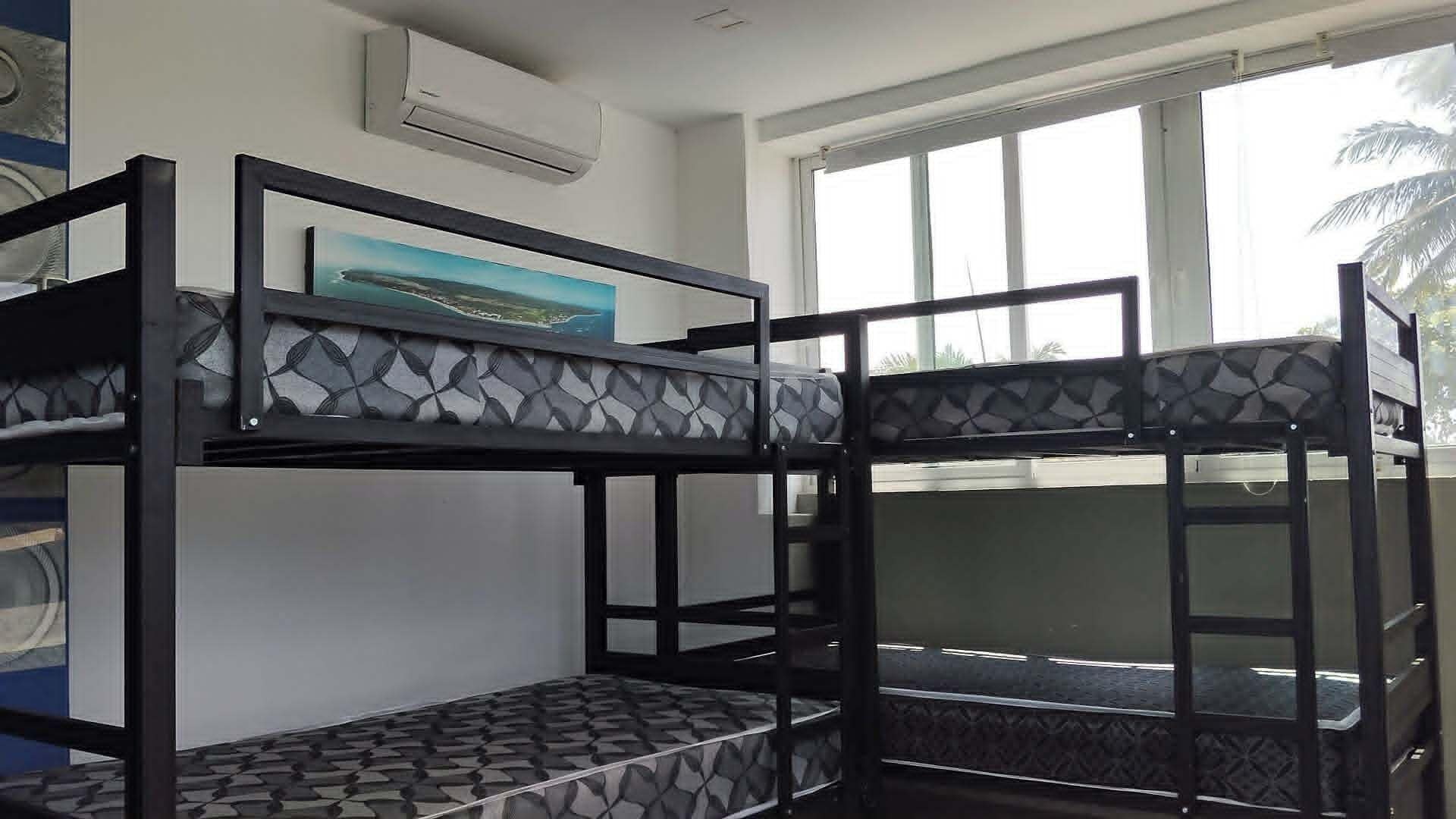Uma cama beliche com colchão estampado e um quadro em cima.