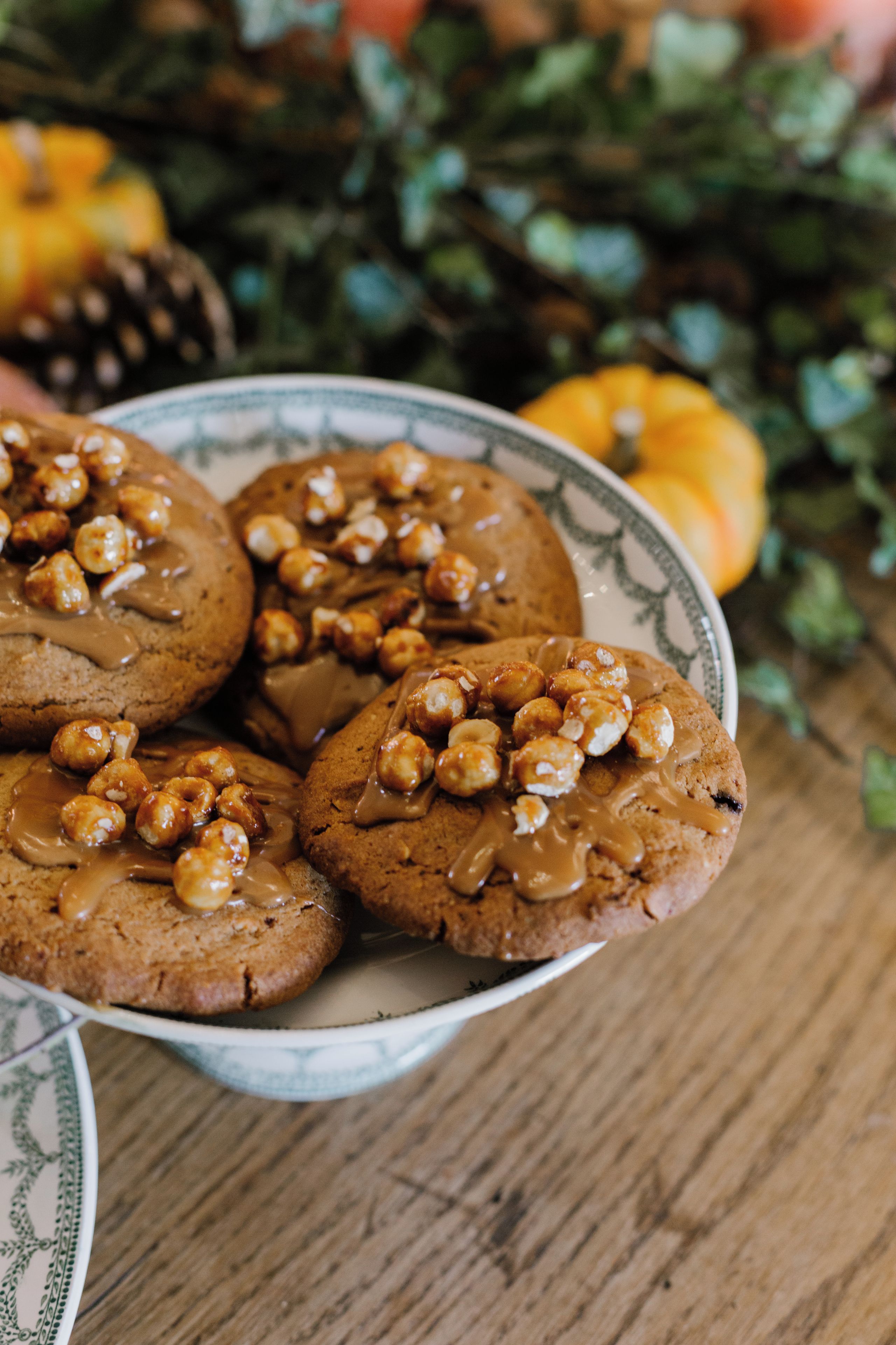 Uma tigela de biscoitos com nozes sobre um prato estampado.