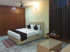 Quarto com cama, guarda-roupa de madeira, mesa de cabeceira e janela com cortinas.