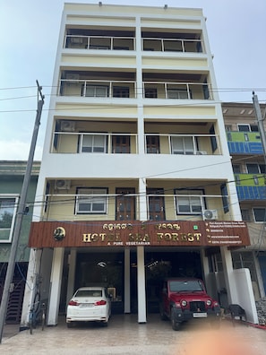 Um edifício de vários andares com uma placa indicando 'HOTEL SEA FOREST', um hotel vegetariano.