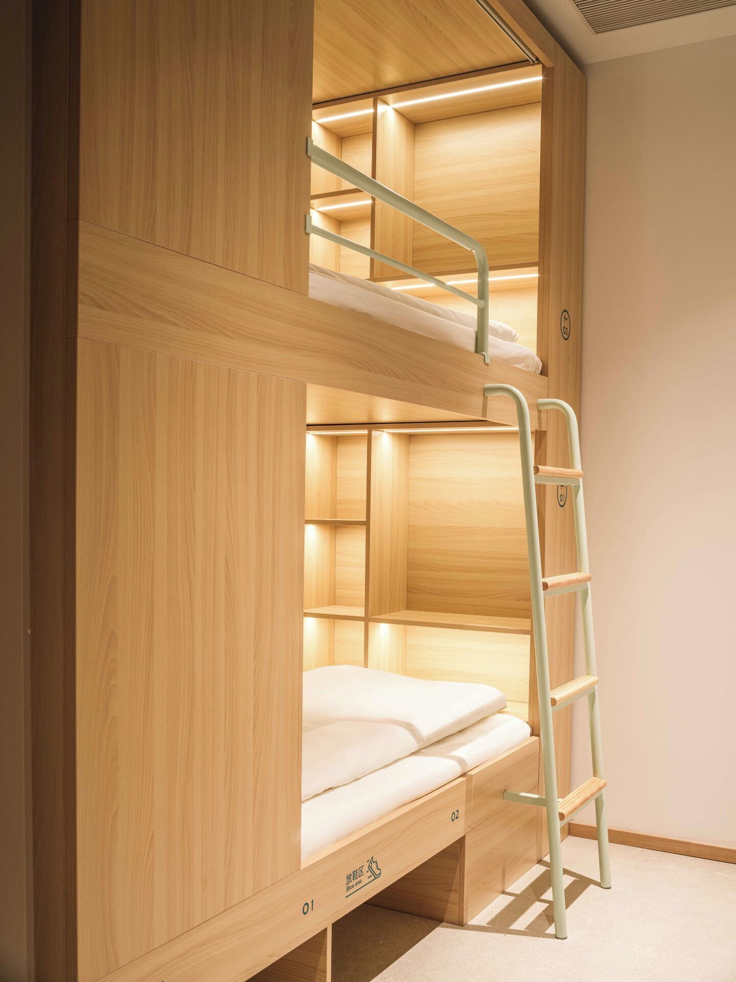 Uma cama beliche com escada, paredes de madeira e o número '02' na lateral.
