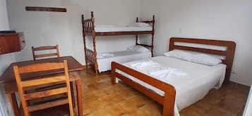Quarto com cama de solteiro, uma cama individual, uma cadeira de madeira e uma mesinha.