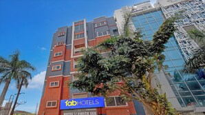 Um hotel com vários andares e um destaque para a placa 'fab hotels', indicando uma rede de hotéis de marca.