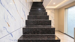Uma escadaria de mármore com design moderno, que dá acesso a um andar superior.