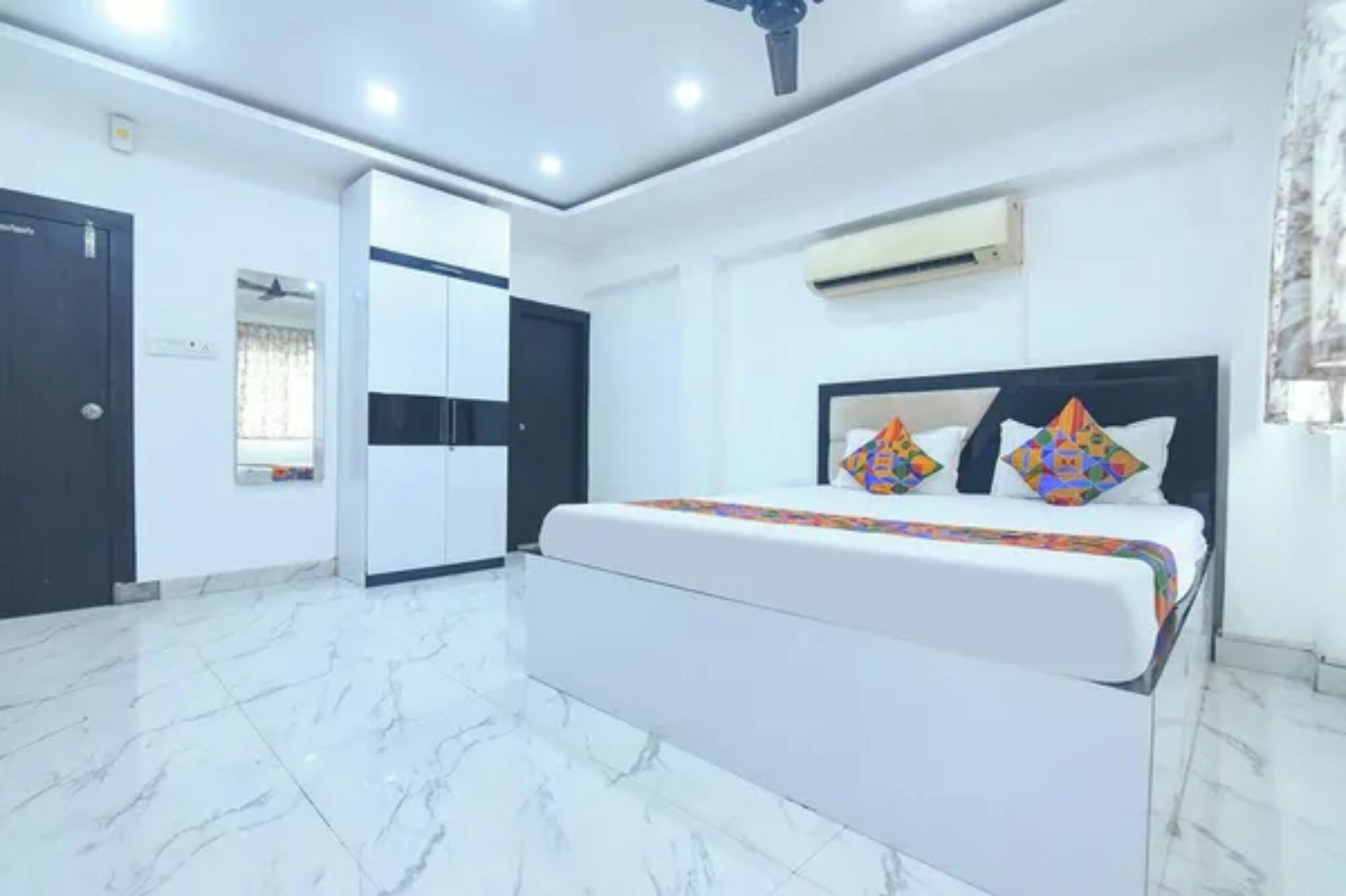Quarto moderno com cama, guarda-roupa e ar condicionado.