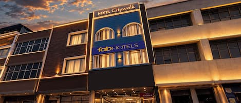 Edifício de hotel com placas indicando 'Hotel Citywalk' e 'Fair Hotels'.
