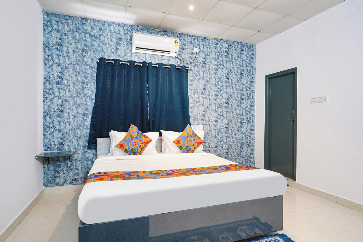 Quarto com cama, cortinas, ar condicionado e porta.