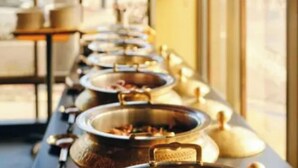 Uma mesa de buffet com diversos pratos em recipientes.