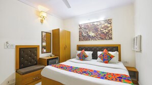 Quarto com cama, mesa de cabeceira, penteadeira, espelho e ventilador de teto.