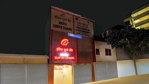 Hotel 'Surya Grand' com placa visível e entrada com persiana fechada.