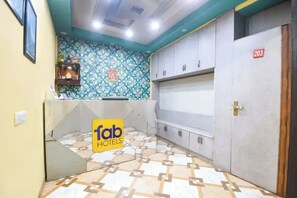 Uma área de recepção de hotel com uma parede estampada, um balcão de recepção e uma porta com o número 203.