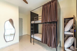 Quarto com beliche, cortina, espelho e armário com travesseiros.