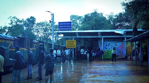Plataforma de estação de trem com uma placa amarela indicando Estação Ferroviária de Matheran.