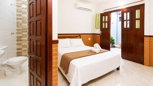 Quarto de hotel com cama, banheiro e vista para o exterior.