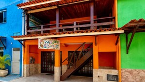 Um edifício com uma placa que diz 'Villa dos Encantos' e uma escadaria que leva a um andar superior.