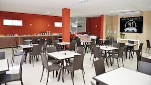 Restaurante com mesas e cadeiras dispostas para refeições.