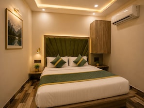 Uma cama bem arrumada com colcha verde e branca, cabeceira de madeira e mesa de cabeceira com abajur.