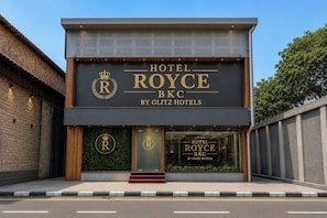 Fachada de hotel com o nome 'Hotel Royale BKC' e um logotipo com uma coroa.